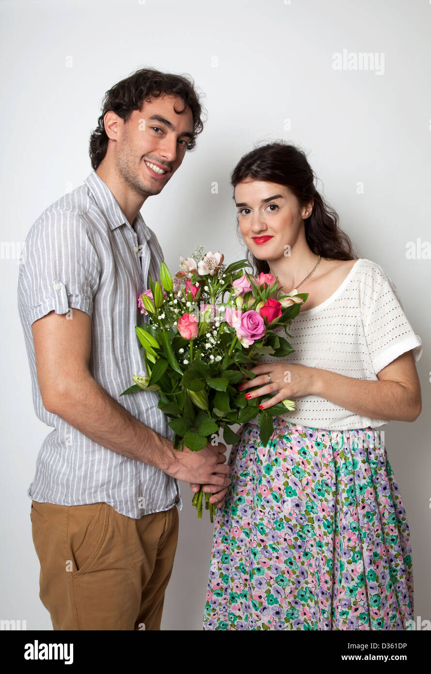 Couple holding bunch of flowers Stock Photo - Alamy