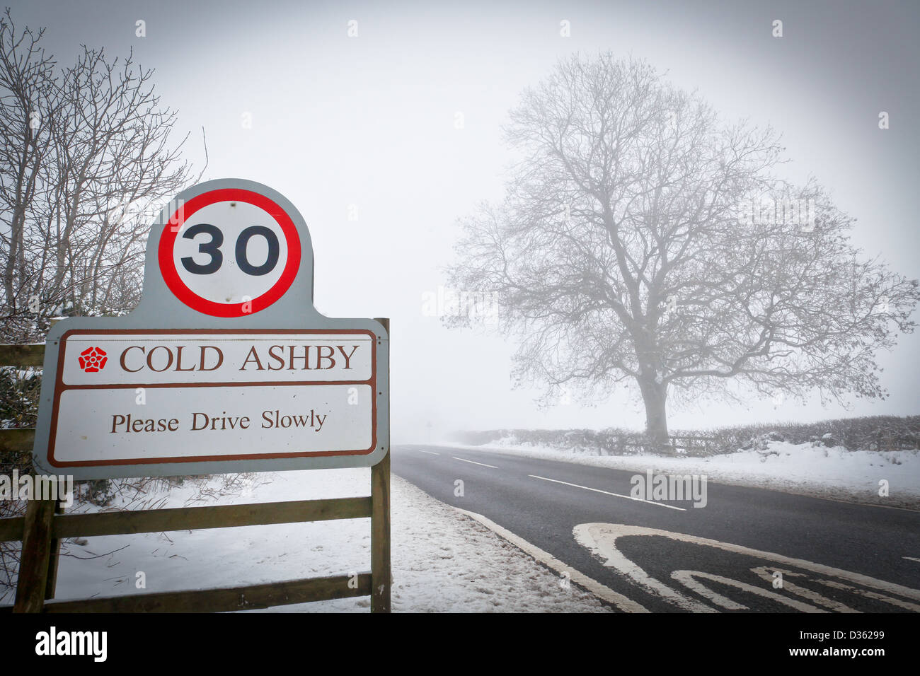 Snowy scene with village sign for Cold Ashby in Northamptonshre Stock ...