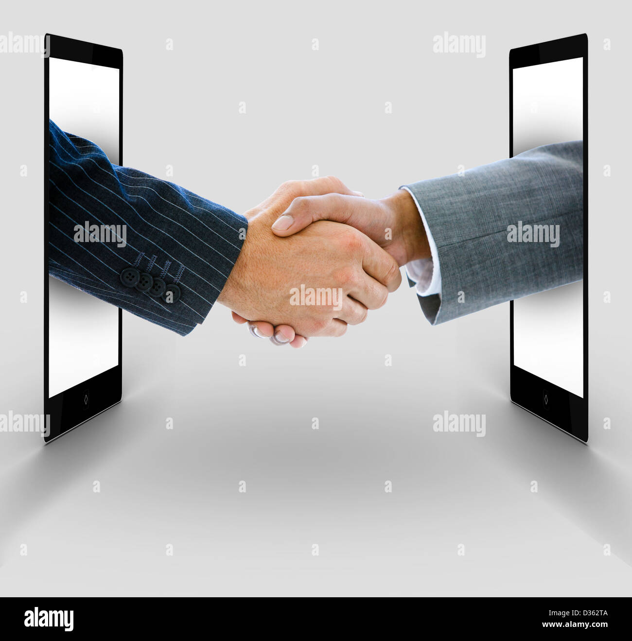 Businessmen shaking hands from digital tablets Stock Photo - Alamy
