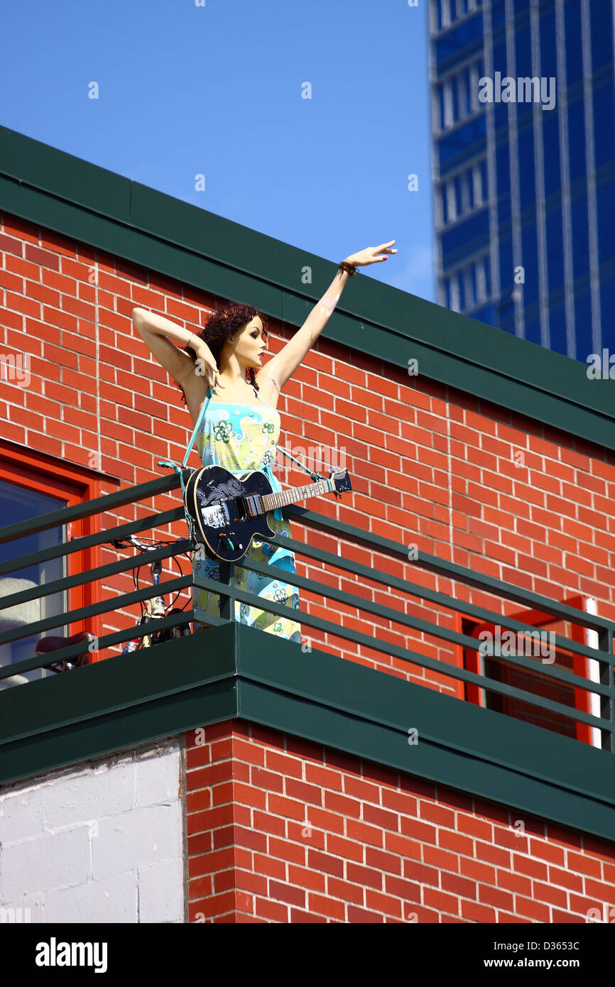 A department store dummy dressed on a balcony with black guitar Stock ...