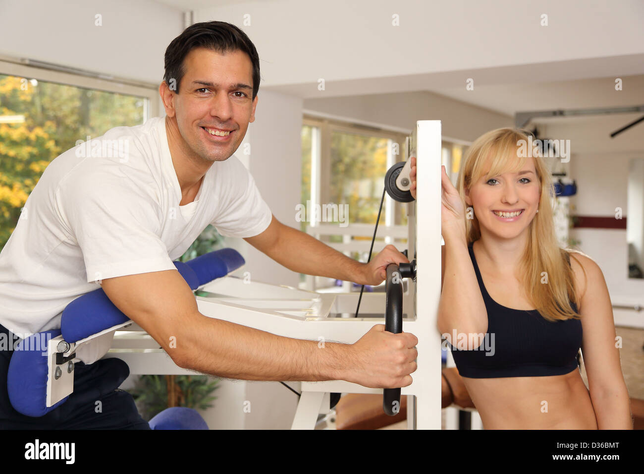 Personal trainer and athletic woman working out in a fitness center ...