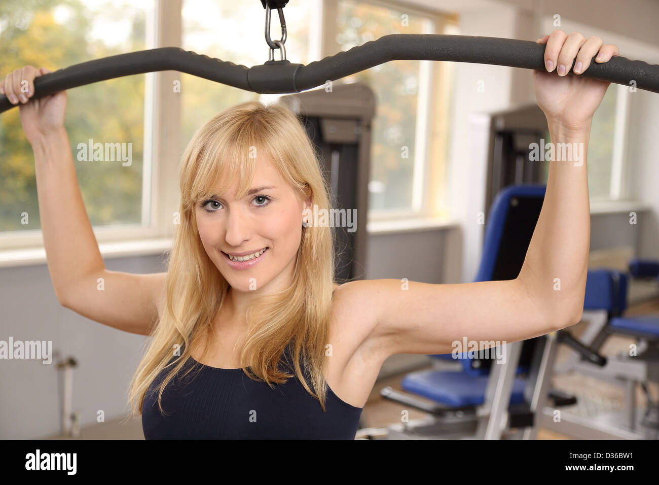 Beautiful young woman working out in a fitness center Stock Photo - Alamy