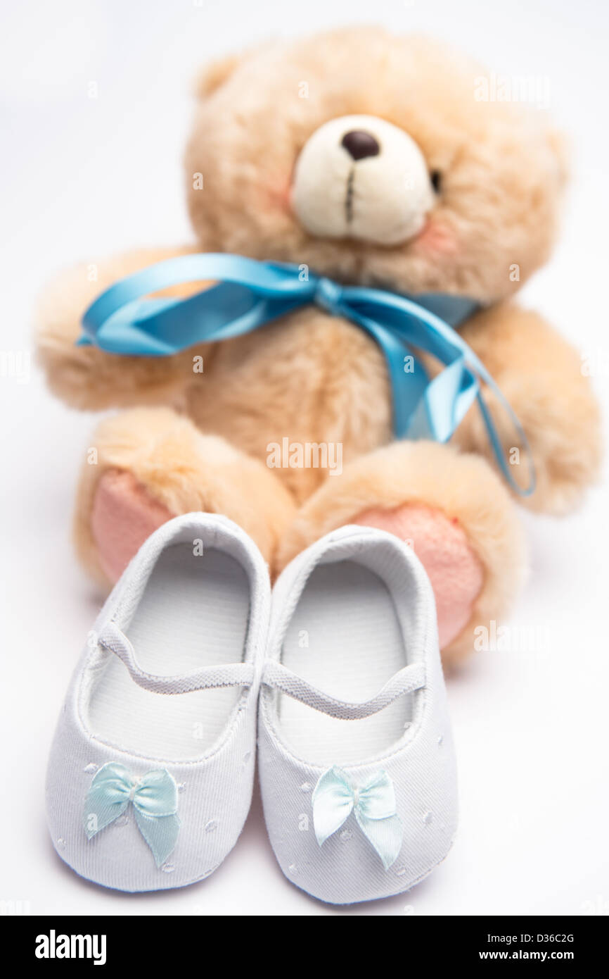 Teddy bear with blue ribbon and white booties Stock Photo - Alamy