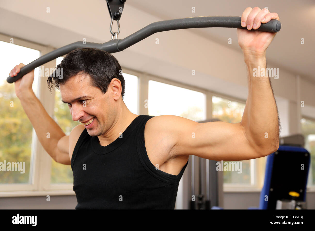 Athletic man exercising and lifting weights in a fitness center Stock ...