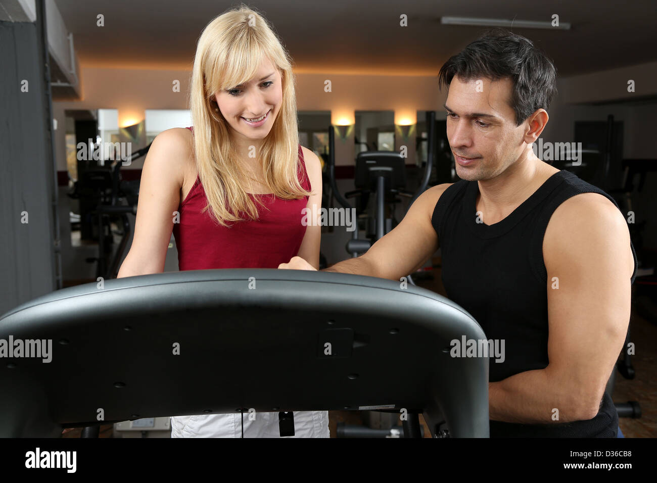 Personal trainer and athletic woman working out in a fitness center ...