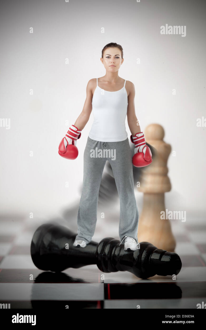 Female boxer standing on black chess piece Stock Photo - Alamy