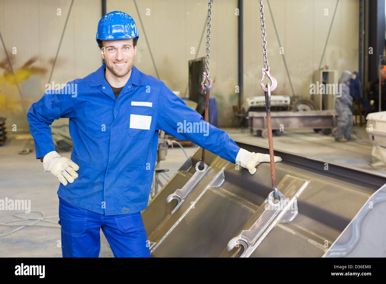 Construction worker standing next to bucket Stock Photo - Alamy