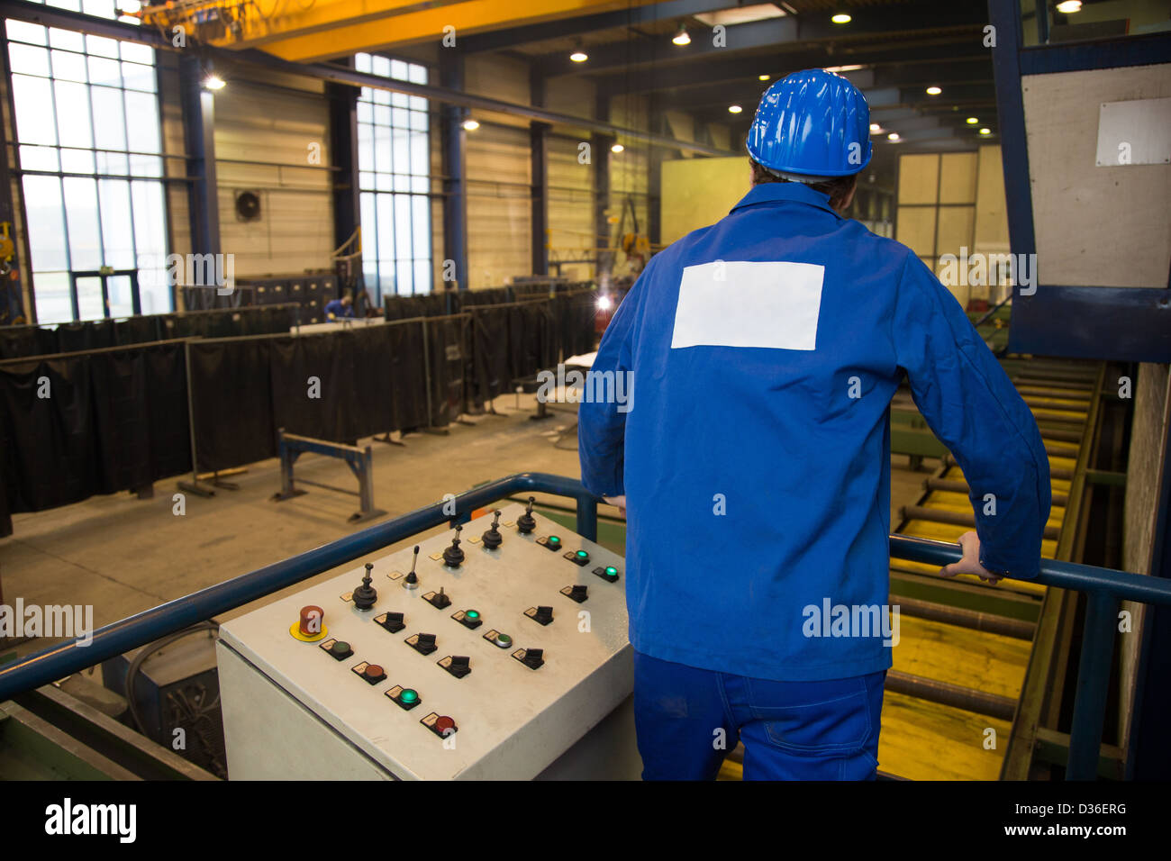 Construction worker operating a crane with a control panel Stock Photo ...