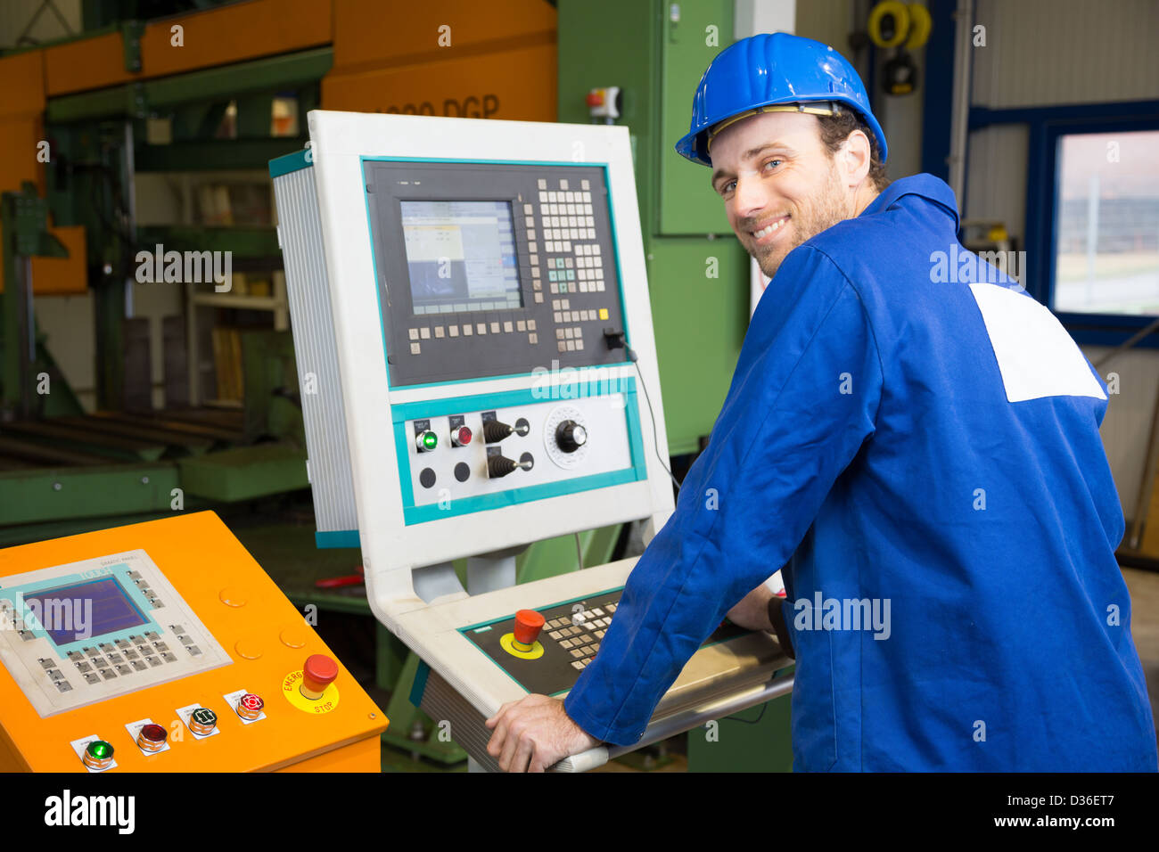 Construction worker operating a large machine with a control panel ...