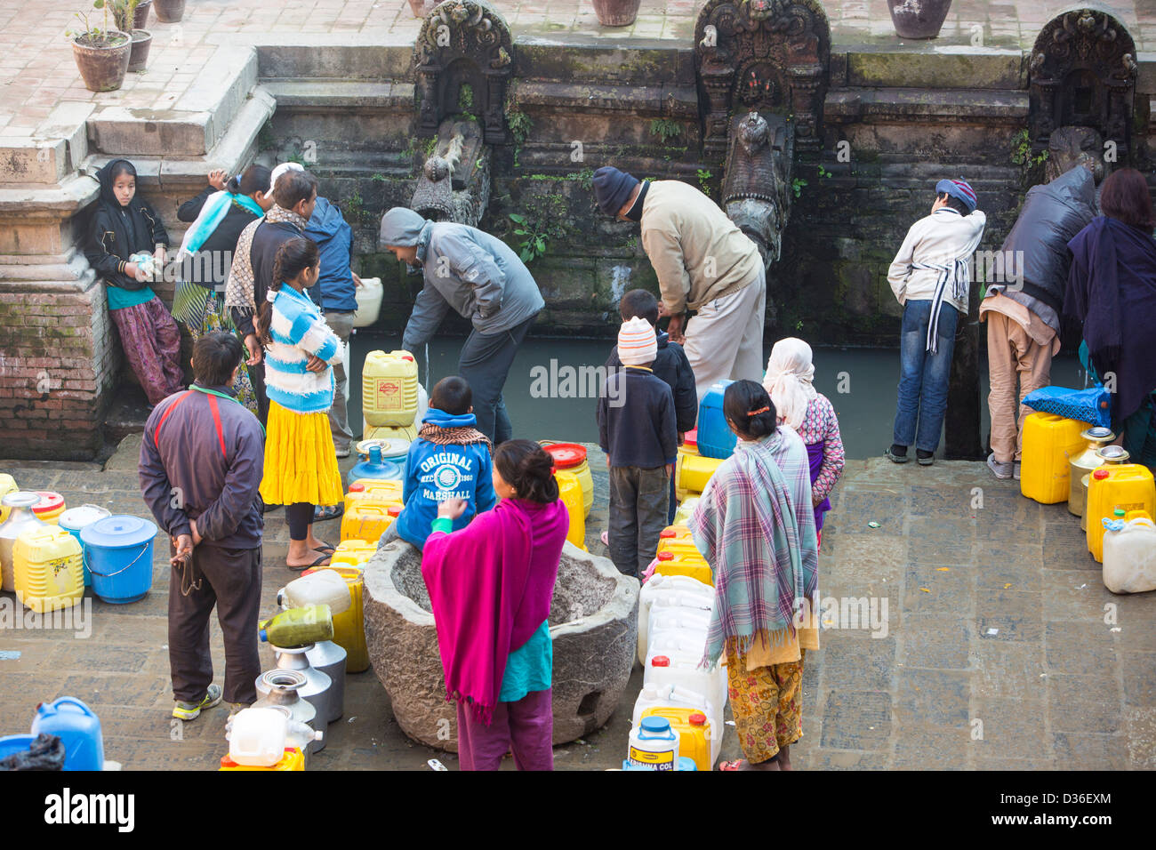 Locals queueing to fill up containers with water at a well in Patan ...
