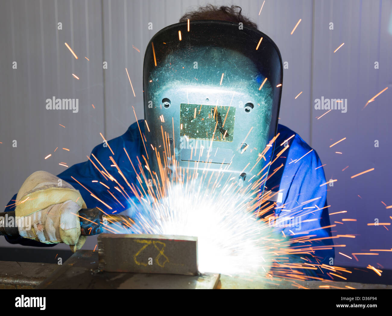 Man with welding helmet welding steel Stock Photo - Alamy