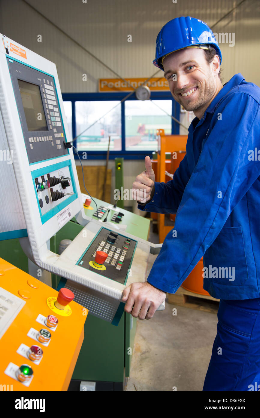 Construction worker operating a large machine with a control panel ...