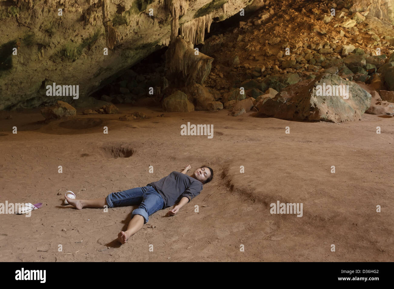 Alone woman sleeping on ground in tropical cave, Thailand Stock Photo ...