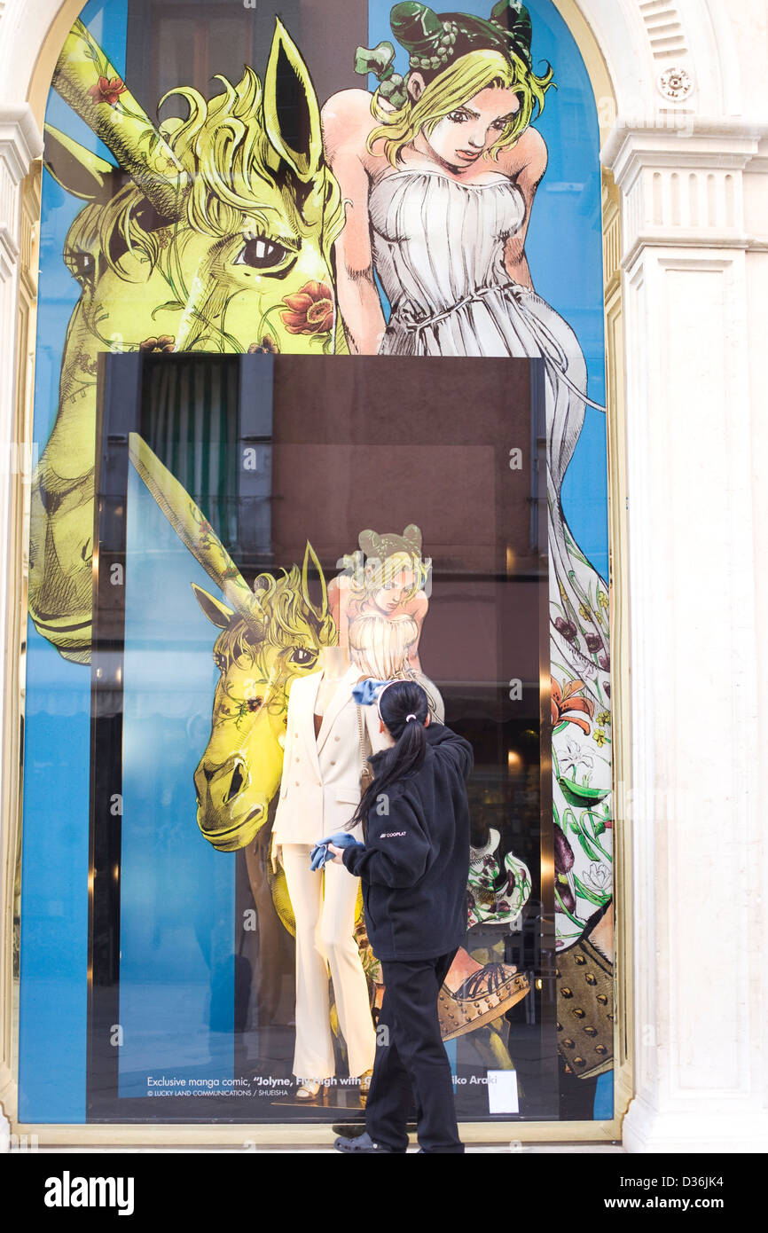 Woman cleaning a Shop window displaying a princess's and a Unicorn ...