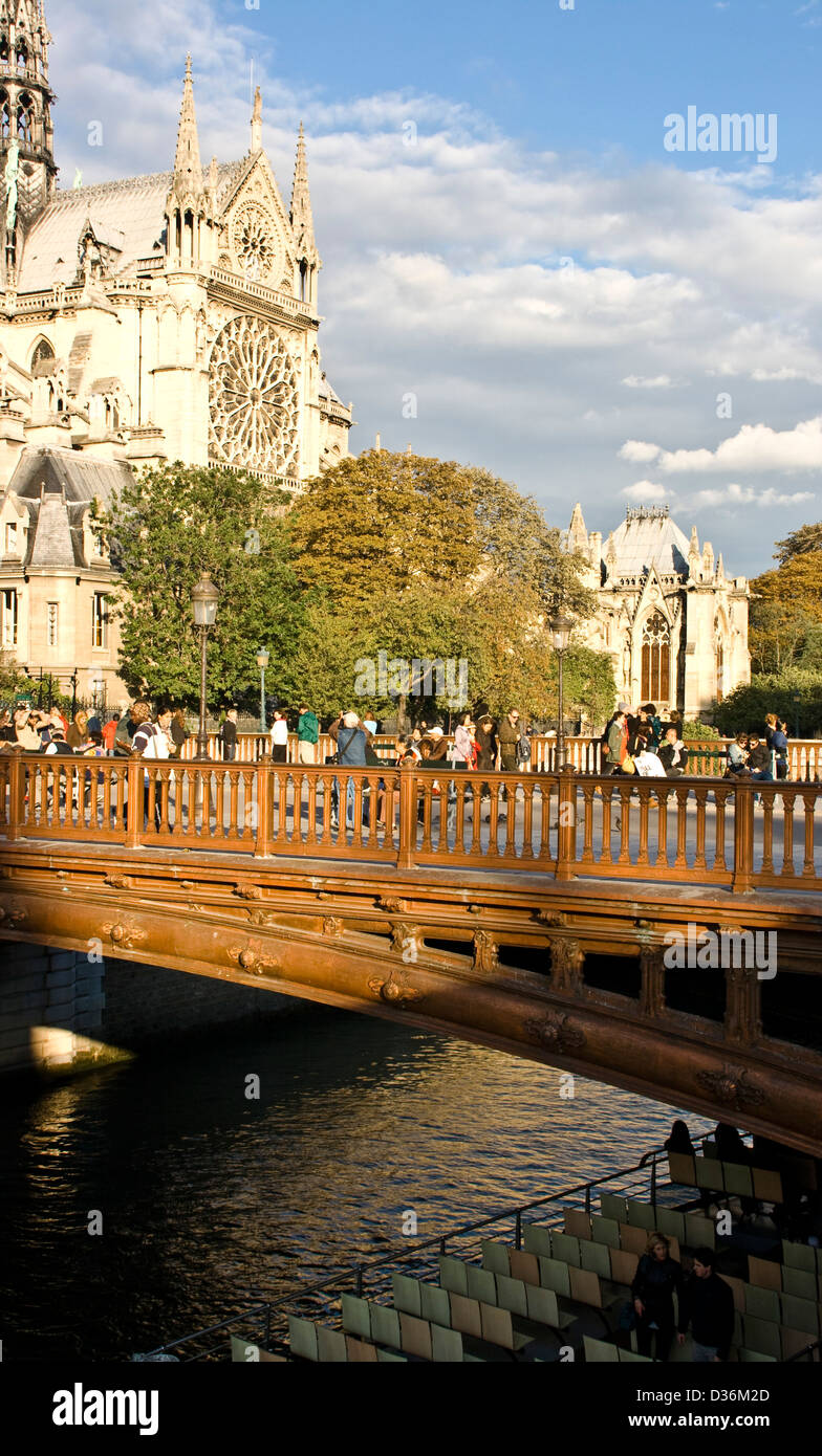 Tourists in dusk sunset sunlight on Pont au Double river Seine Notre ...