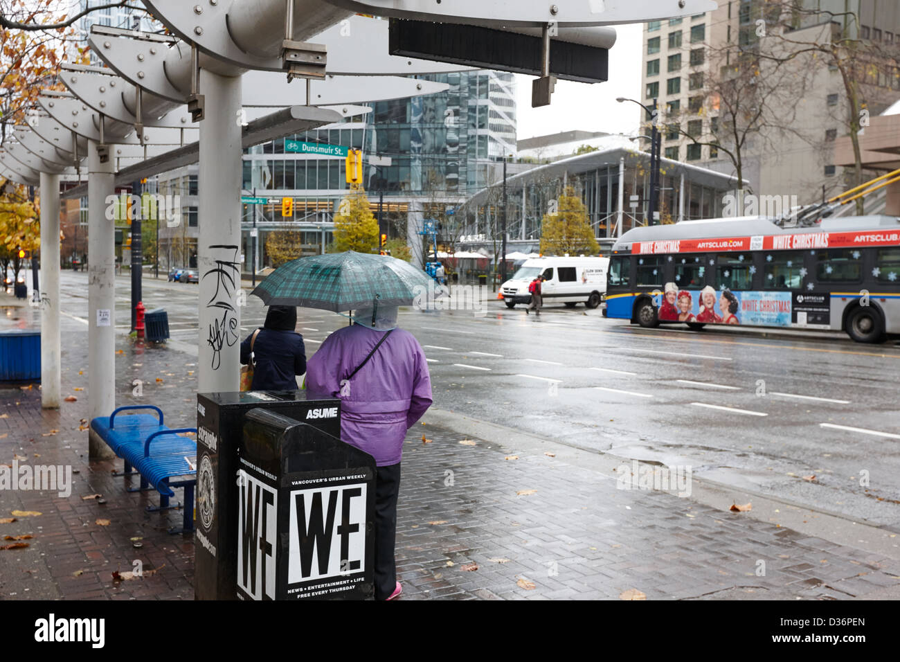 people standing in the rain waiting for a bus on burrard street ...