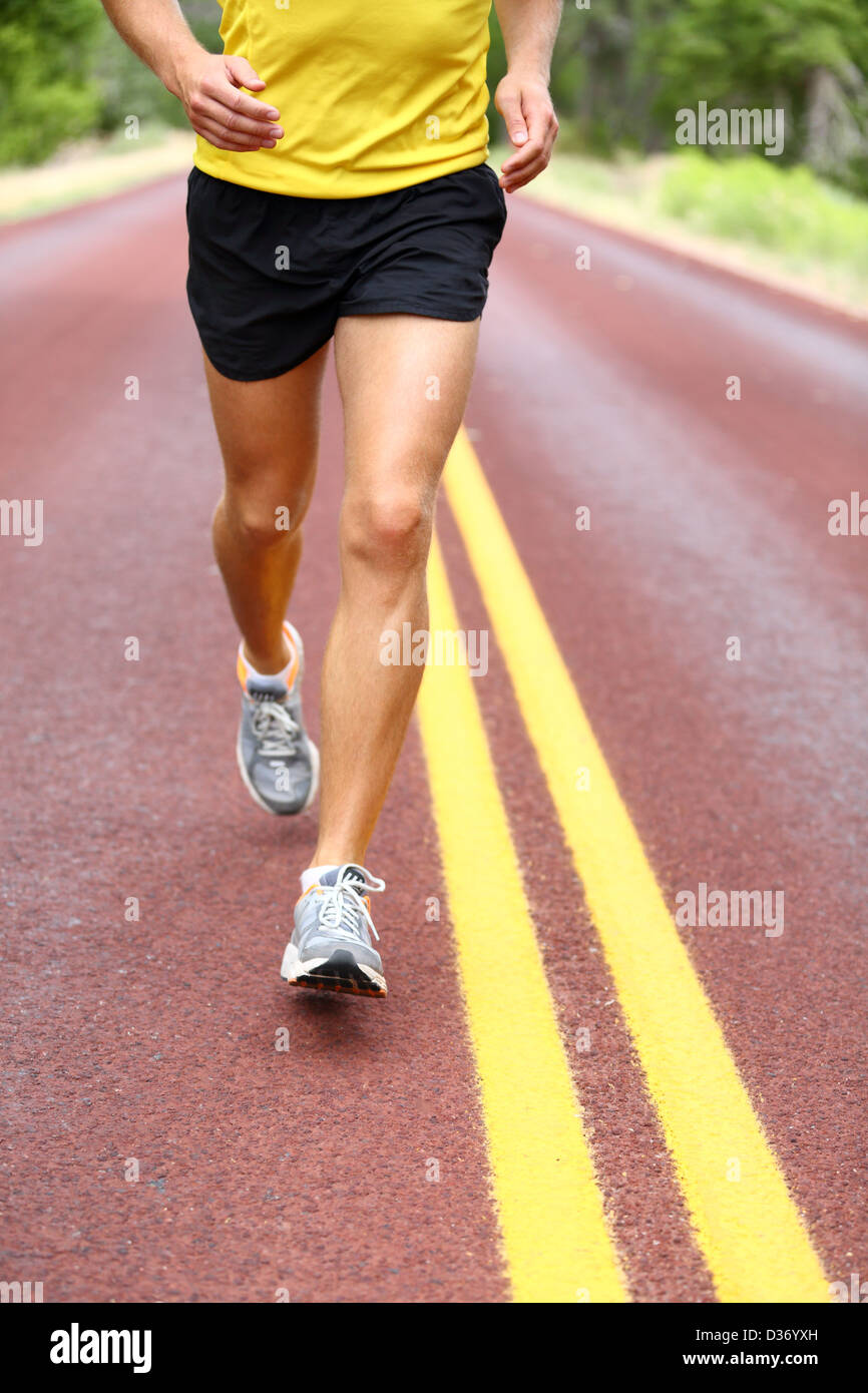 Running man. Runner closeup of running shoes of male legs jogging ...