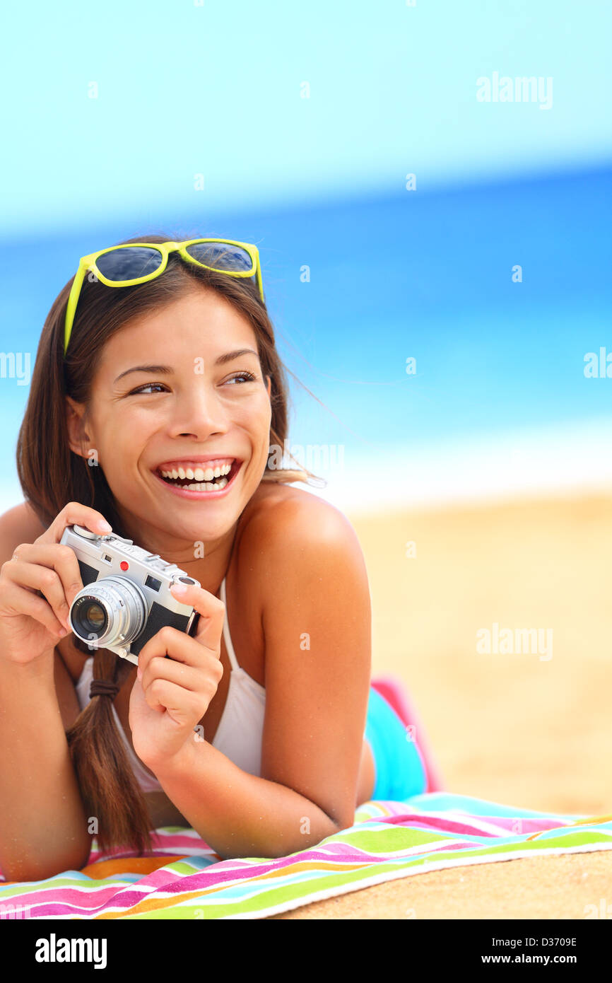 Summer beach woman fun holding vintage retro camera laughing and ...