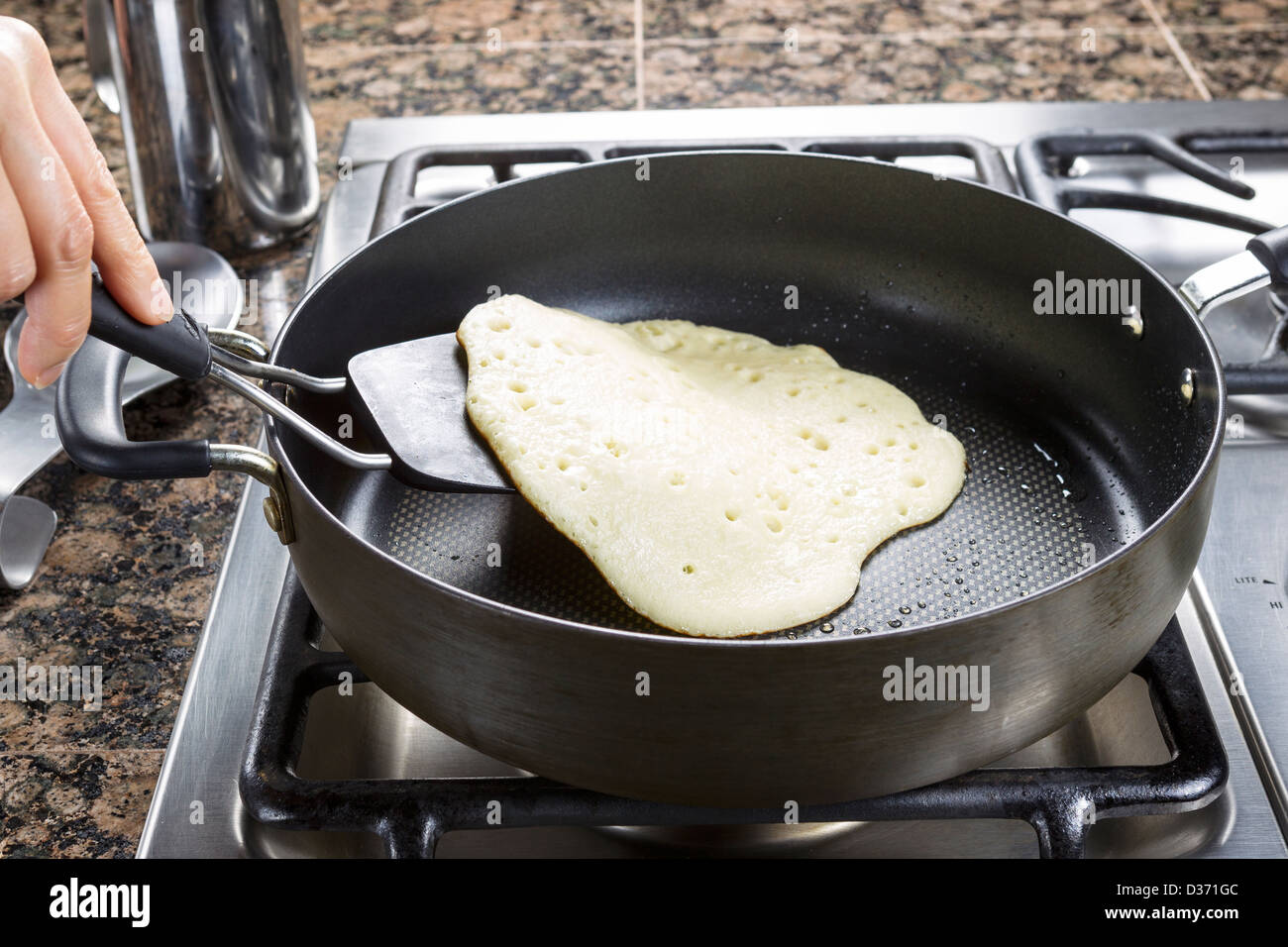 Horizontal photo of focus on pancake batter being fried into a pancake ...