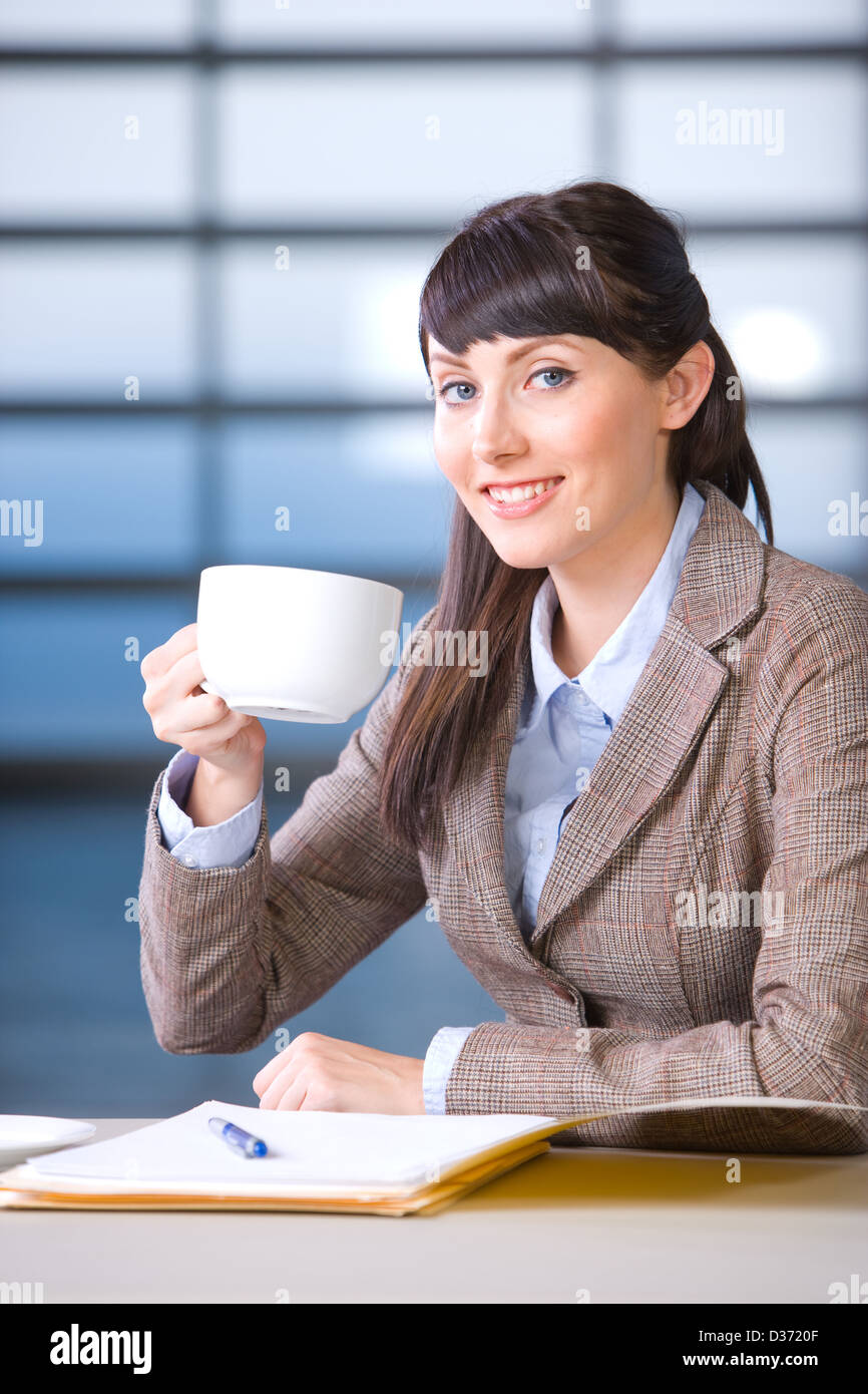 Business Woman drinking Coffee in a modern office Stock Photo - Alamy