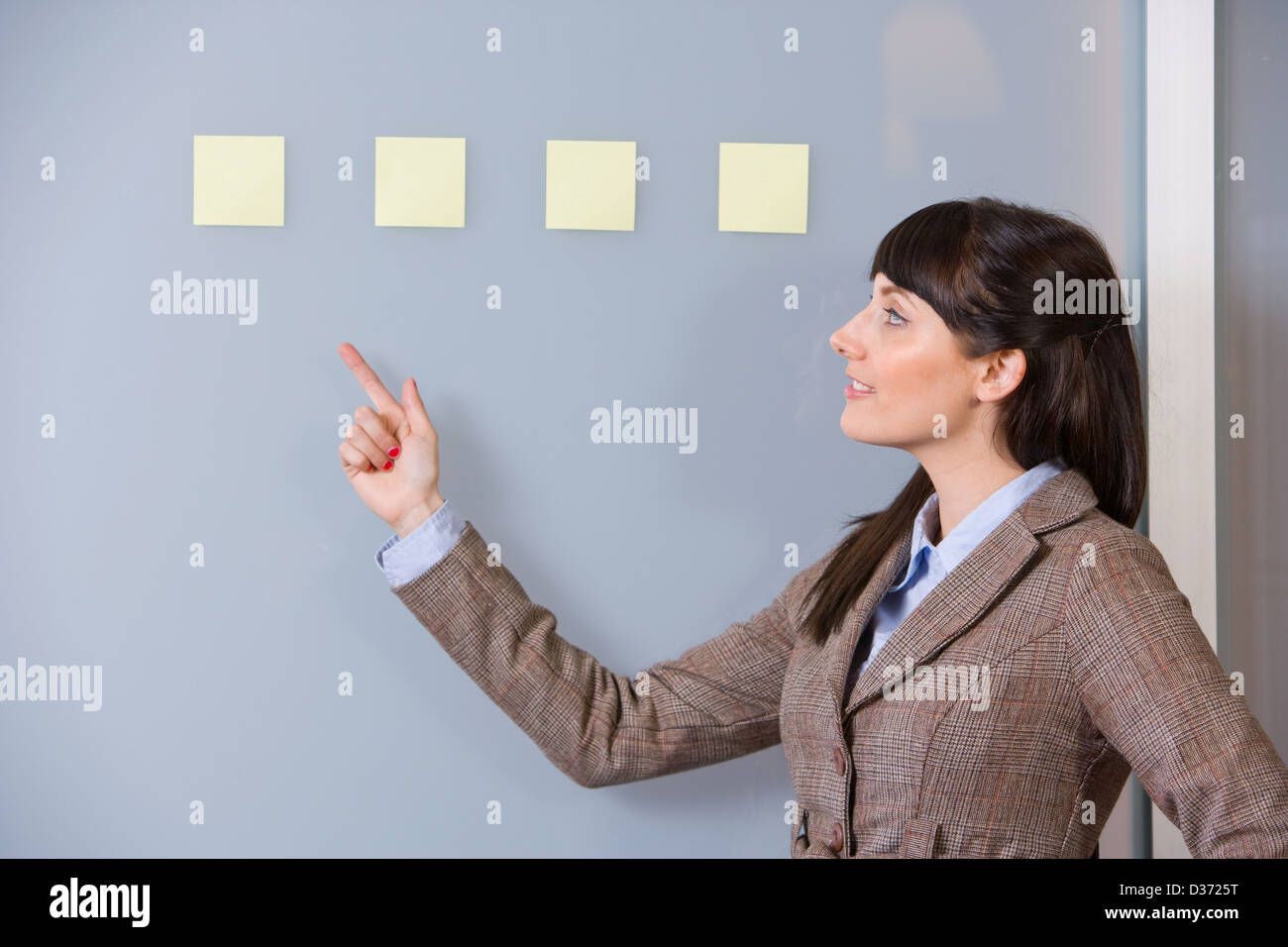 Business Woman pointing to post it notes Stock Photo - Alamy