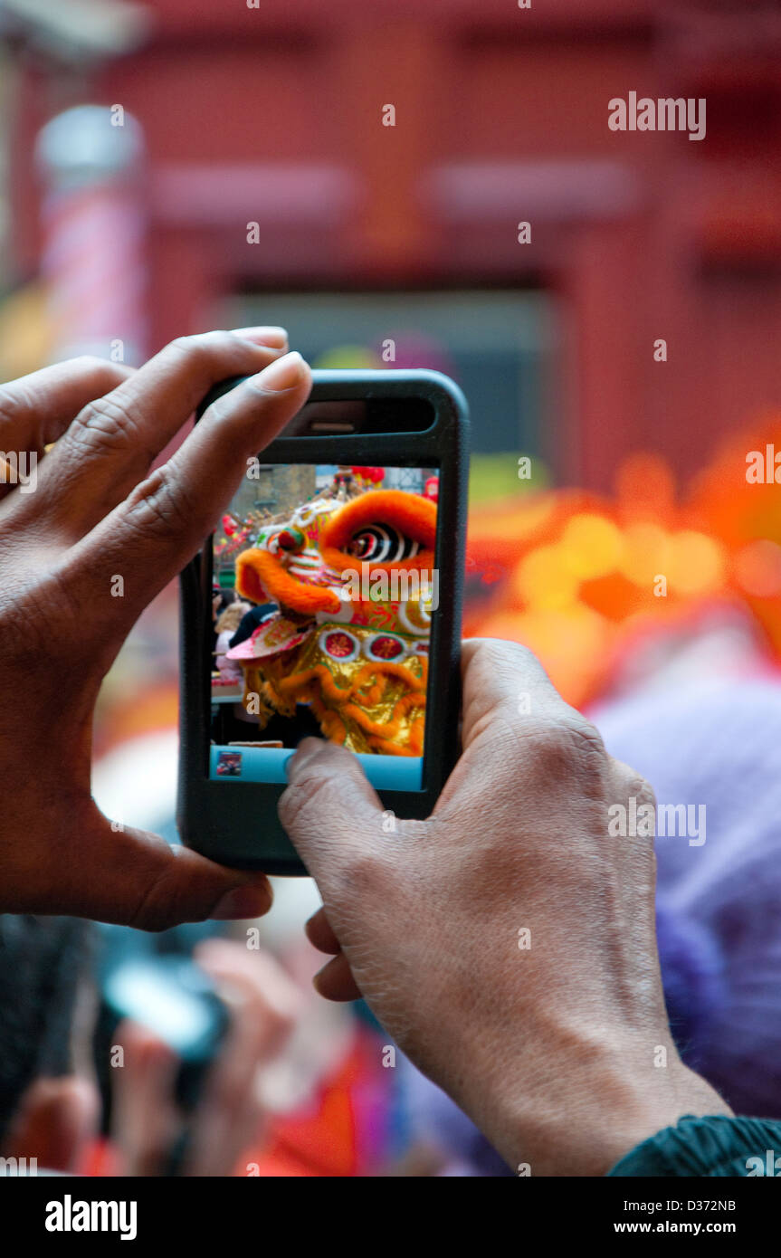 Taking a photo on a phone of a dragon at Chinese New Year celebrations ...
