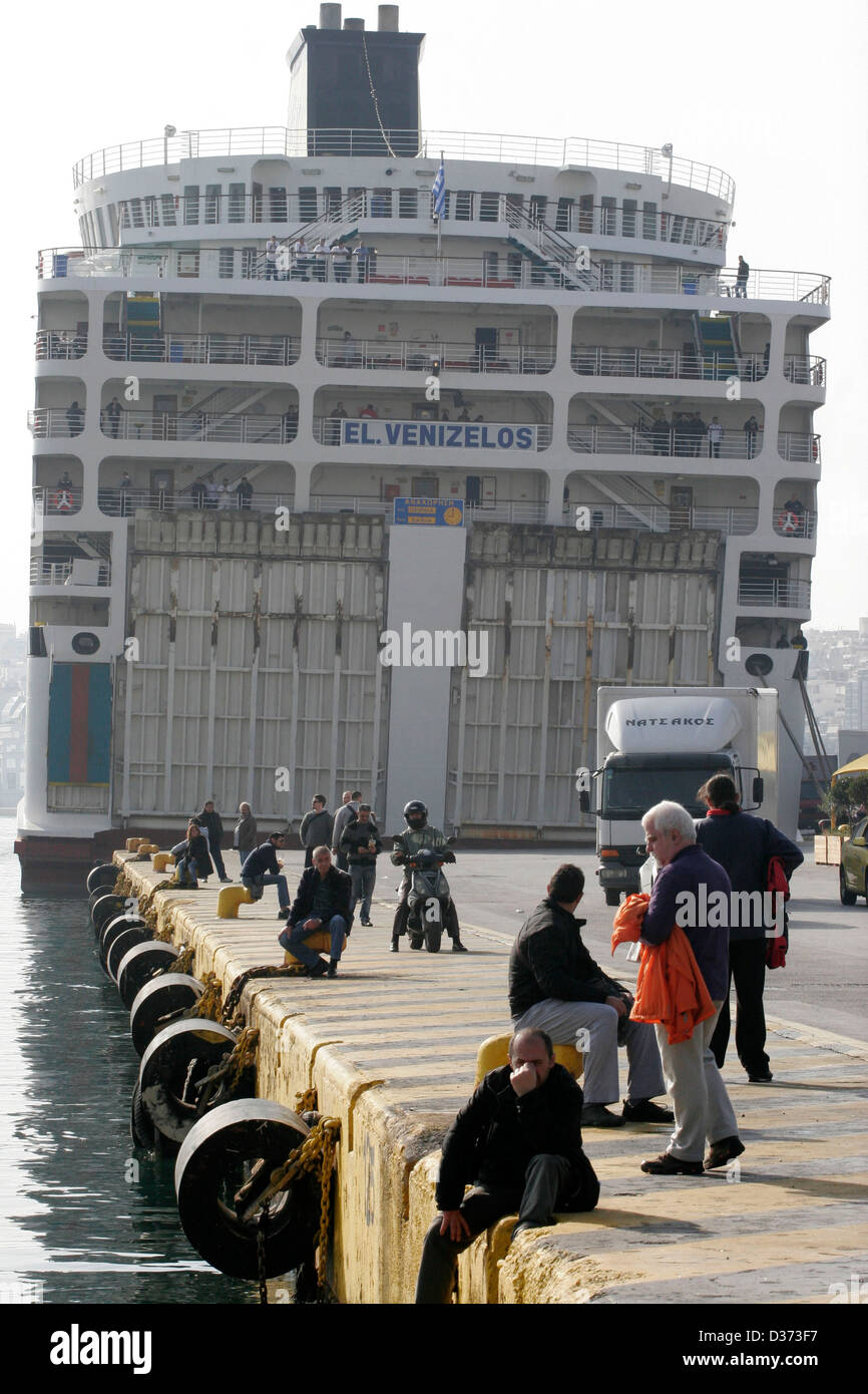 A man sits on a dock at Piraeus harbour Greece Stock Photo - Alamy