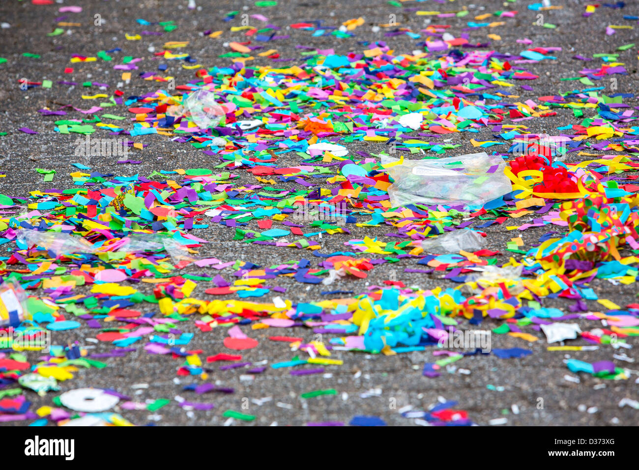 Colored confetti, paper waste on a street, after a carnival parade ...