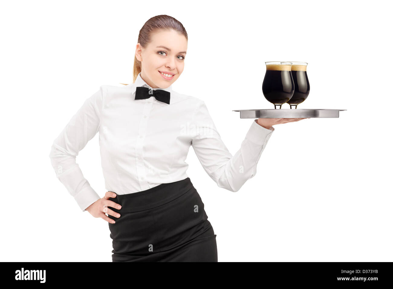 A waitress with bow tie holding a tray with two glasses of dark beer on ...