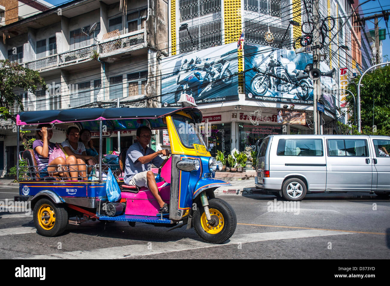 BANGKOK - THAILAND: A tuc tuc carries some tourists through the city in Bangkok Stock Photo - Alamy