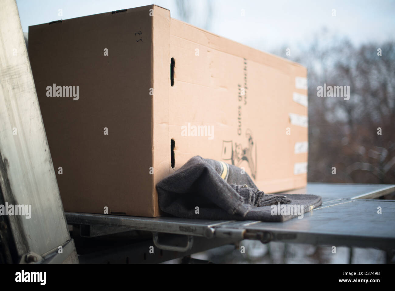 Boxes on a lift being elevated from the moving van during a flat moving ...