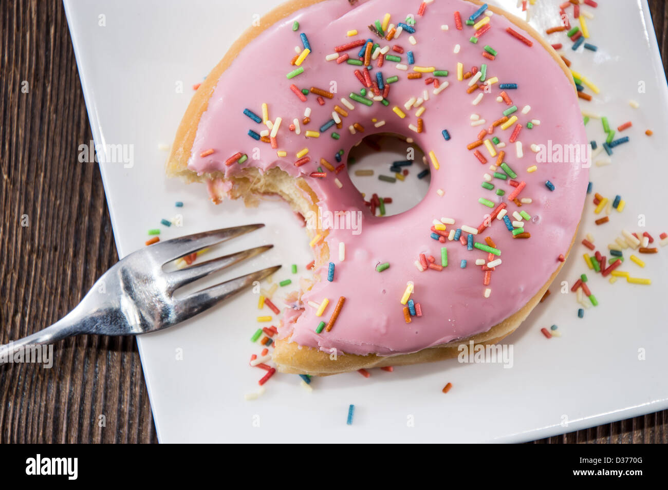 Single Pink Donut on a plate (wooden background Stock Photo - Alamy