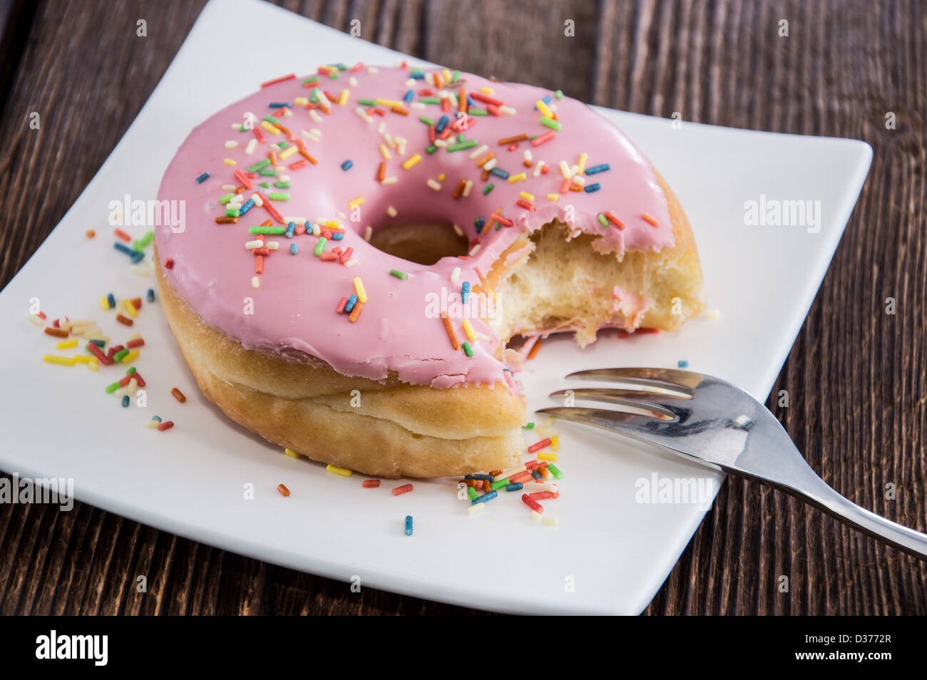 Single Pink Donut on a plate (wooden background Stock Photo - Alamy