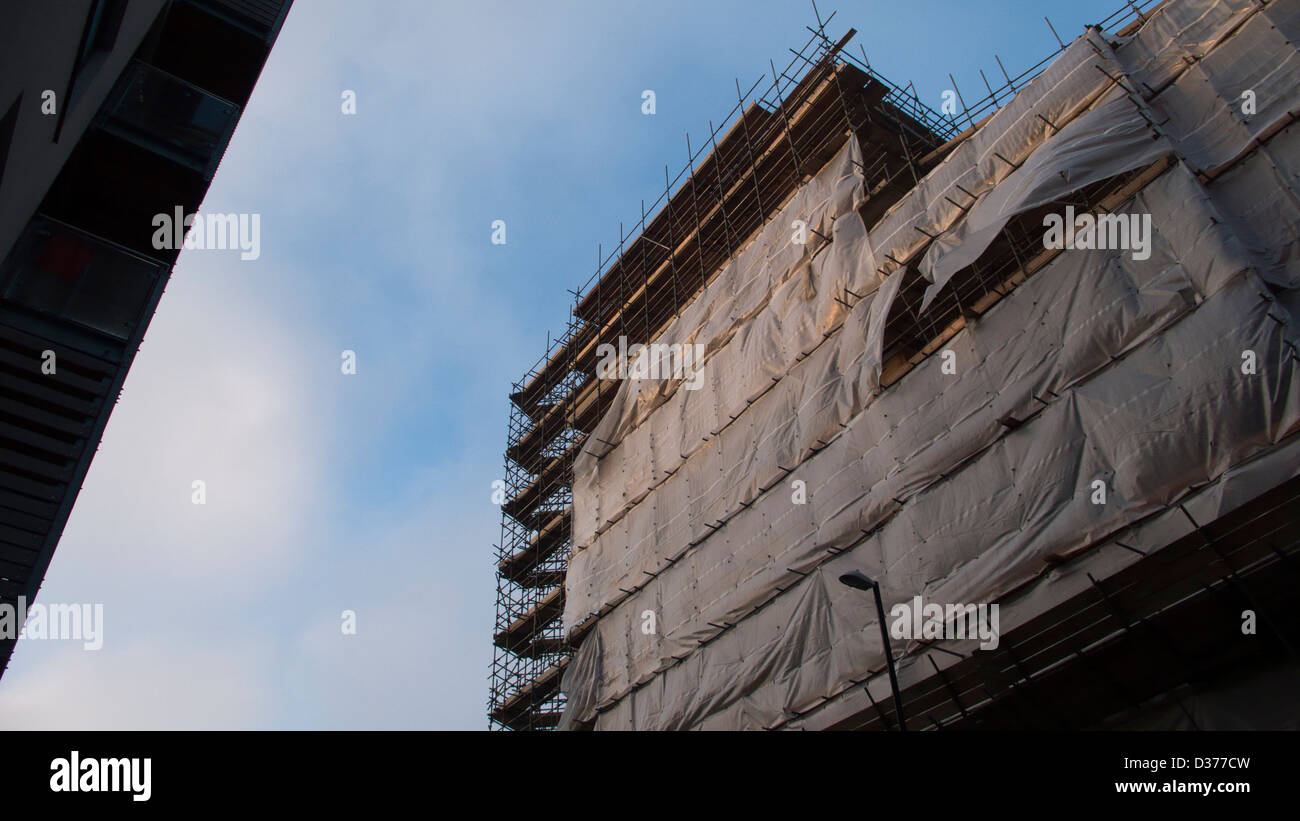 Scaffolded building, partly wrapped Stock Photo - Alamy