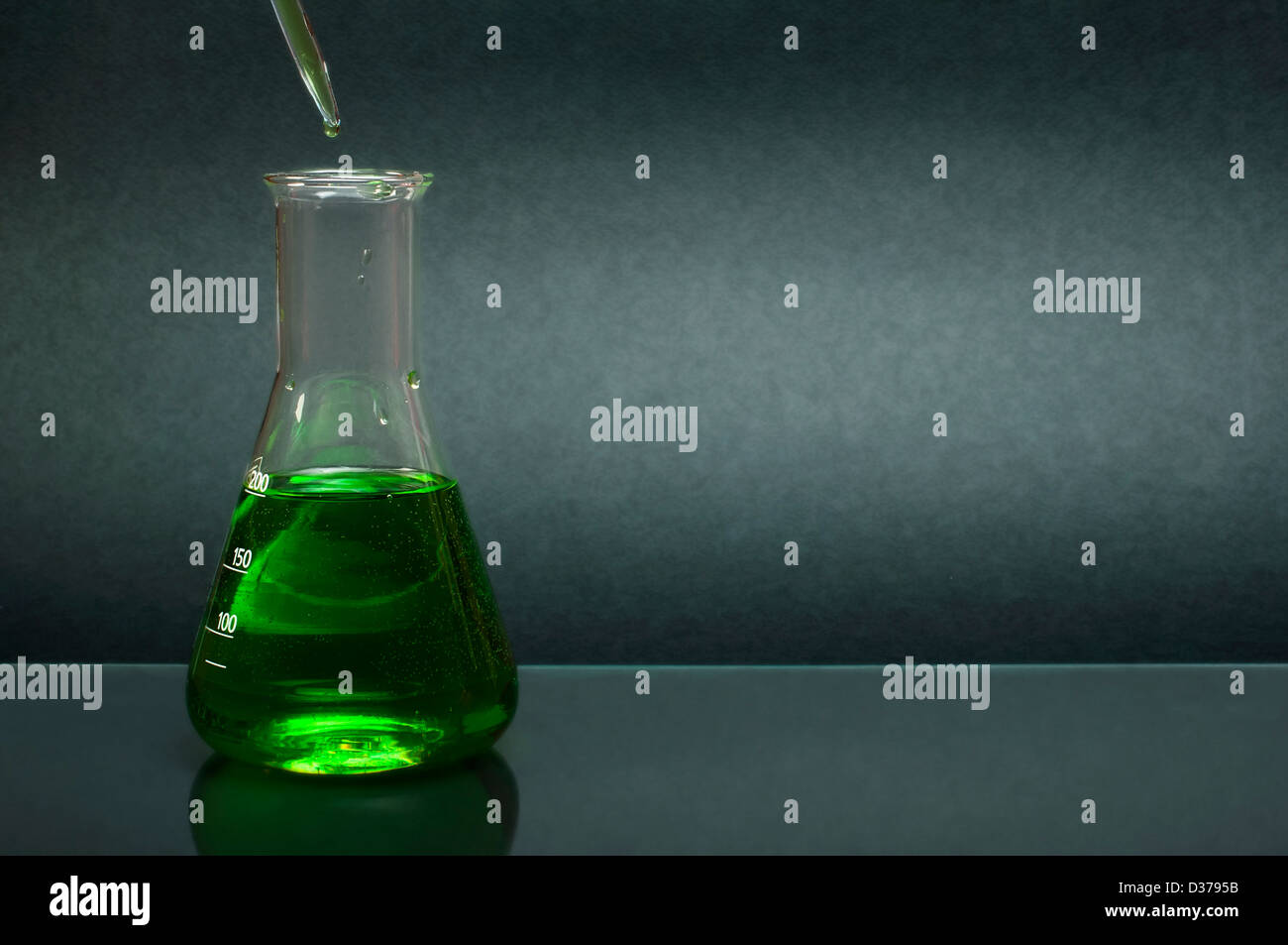 Laboratory beaker filled with green color liquid substances and ...