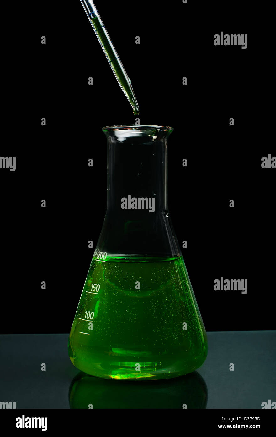 Laboratory beaker filled with green color liquid substances and ...