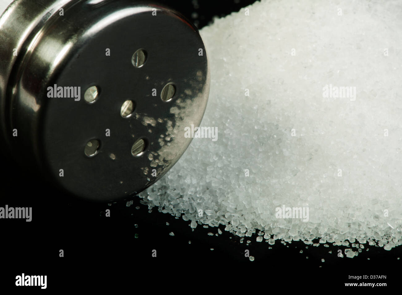 Pile of spilled salt and saltshaker black isolated Stock Photo - Alamy