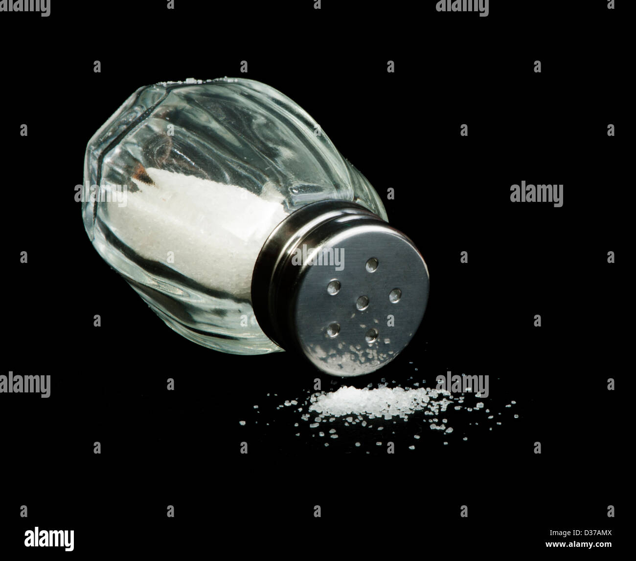 Pile of spilled salt and saltshaker black isolated Stock Photo - Alamy