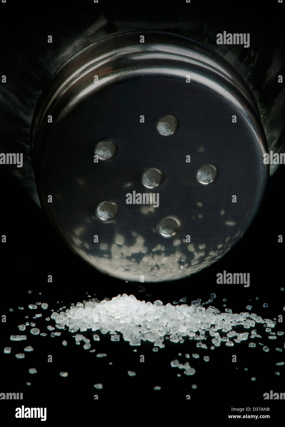 Pile of spilled salt and saltshaker black isolated Stock Photo - Alamy