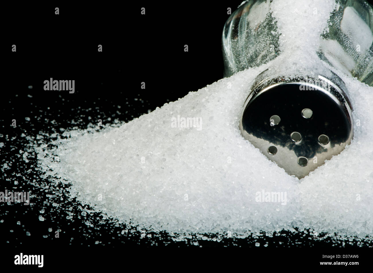 Pile of spilled salt and saltshaker black isolated Stock Photo - Alamy