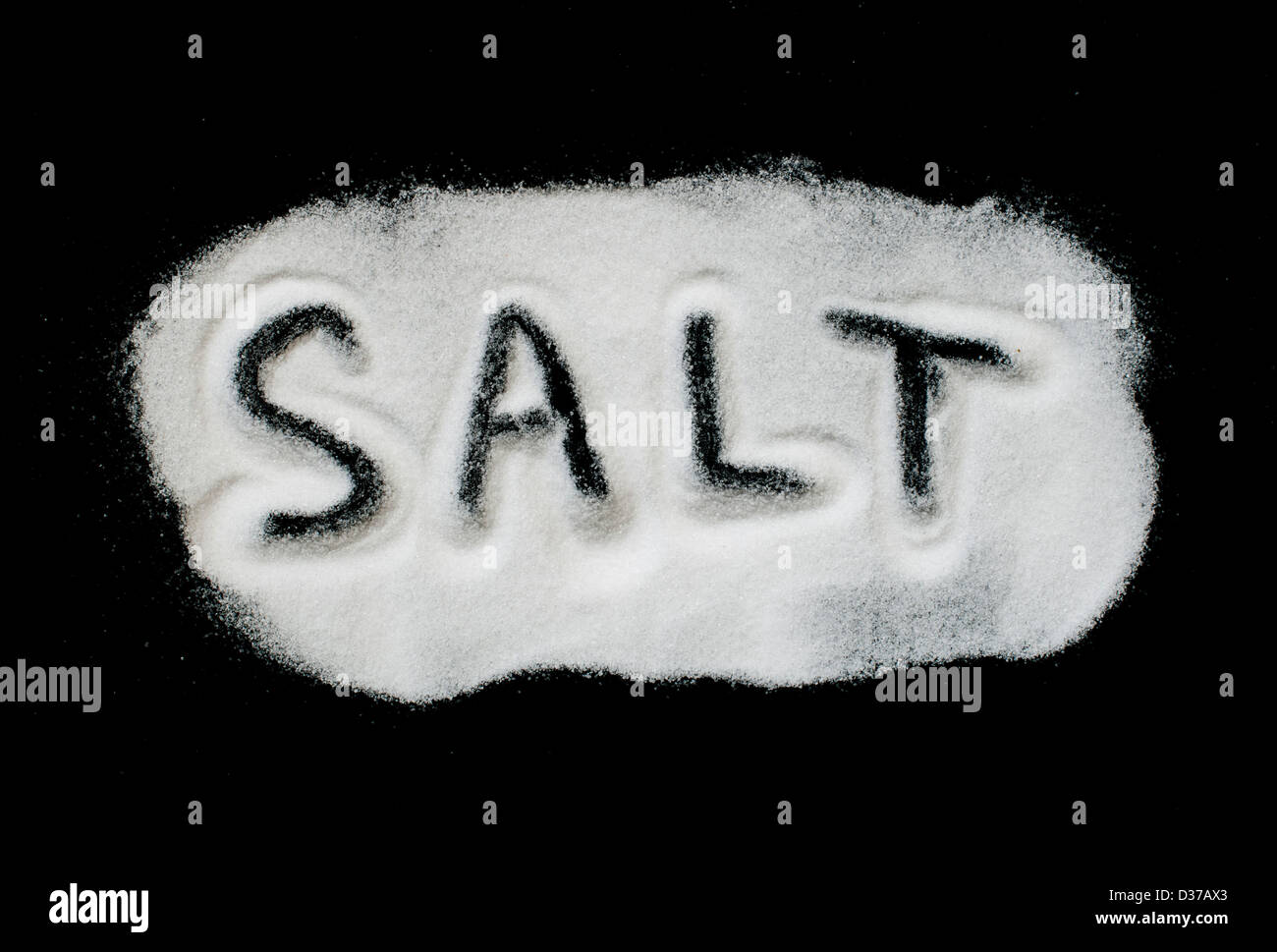 Word Salt on black background written by spilled salt Stock Photo - Alamy