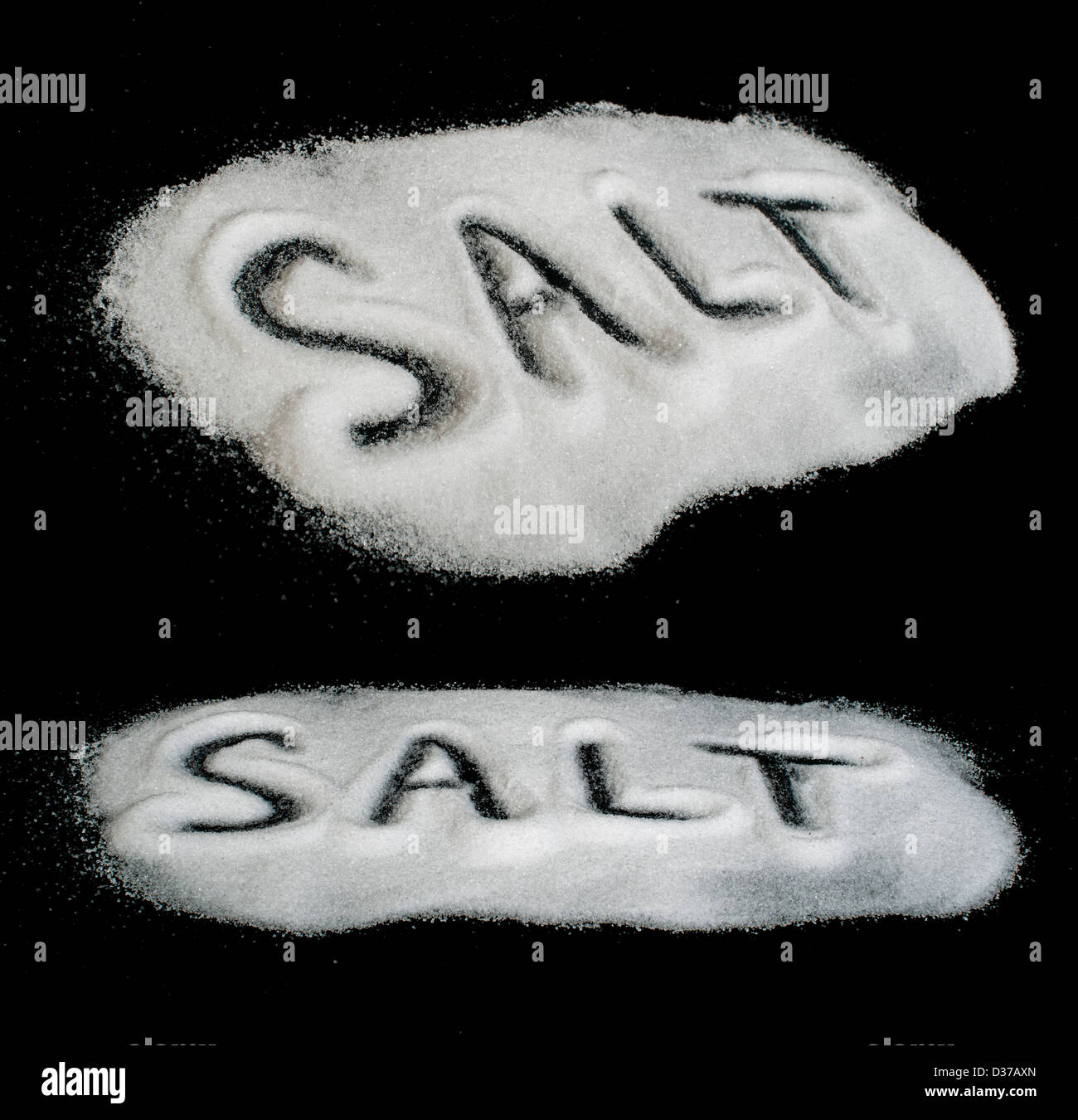 Word Salt on black background written by spilled salt Stock Photo - Alamy