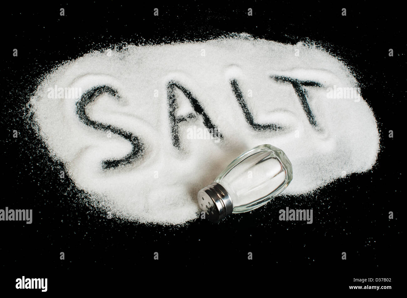Word Salt on black background written by spilled salt Stock Photo - Alamy