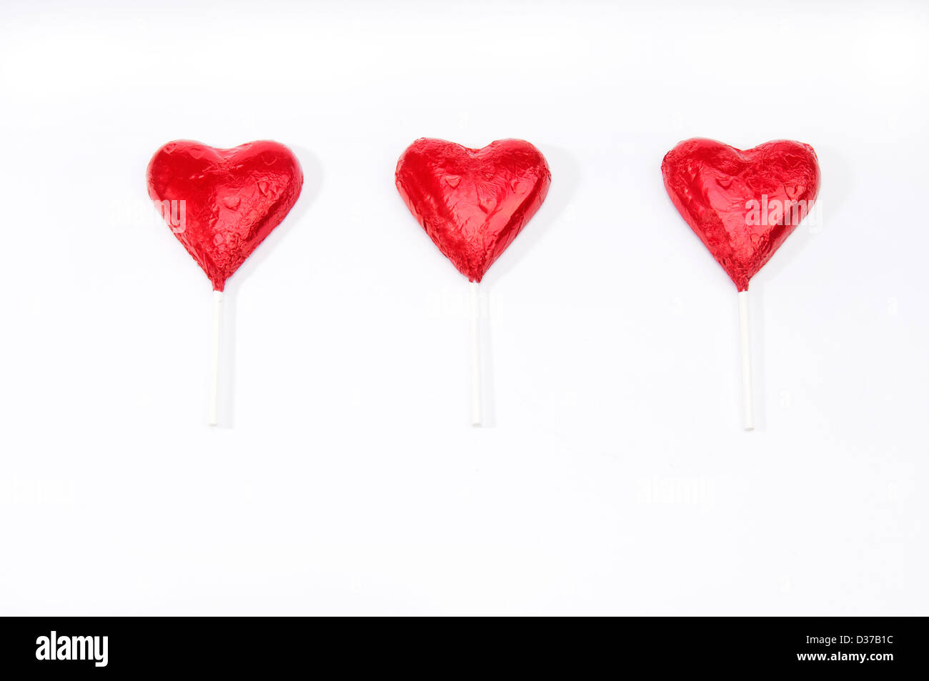 Three red hearts on sticks in a row Stock Photo - Alamy