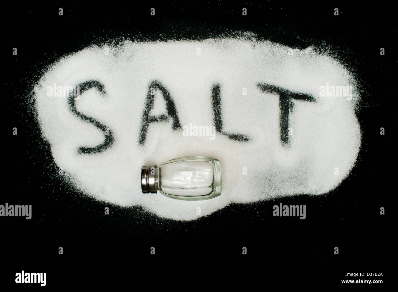 Word Salt on black background written by spilled salt Stock Photo - Alamy