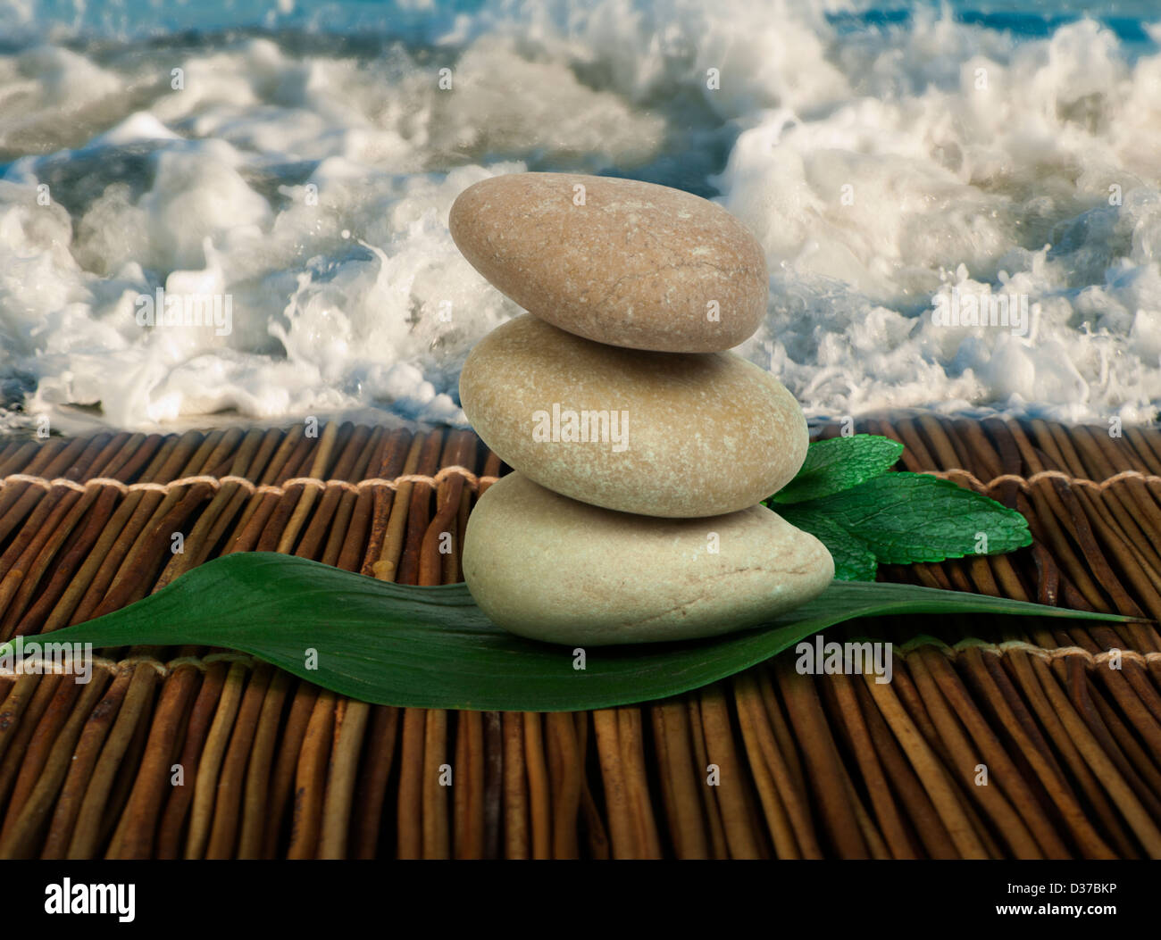 Stacked stones on wooden base for spa and green leafs. Waves on the ...