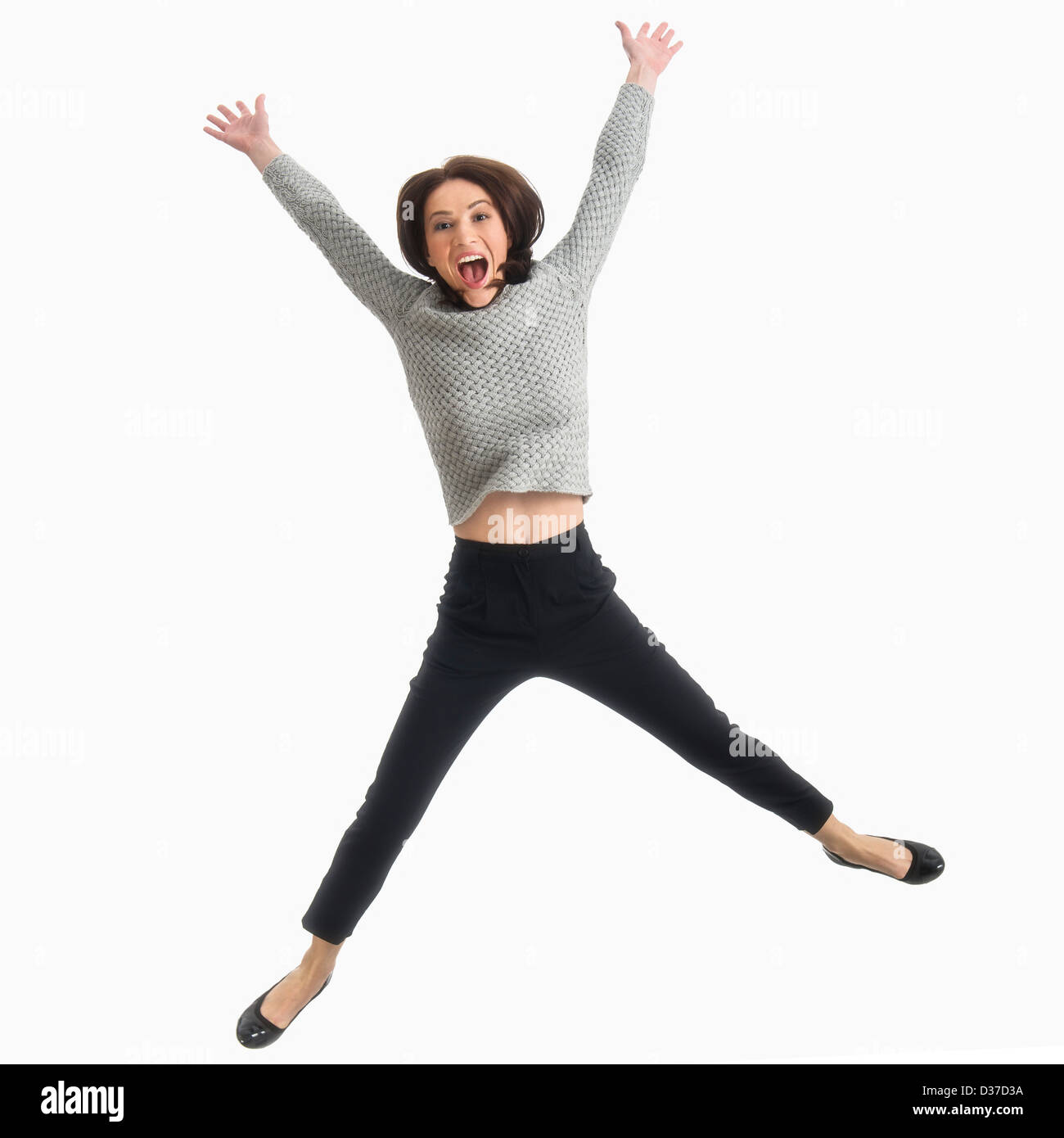 Studio portrait of mid adult woman jumping Stock Photo - Alamy