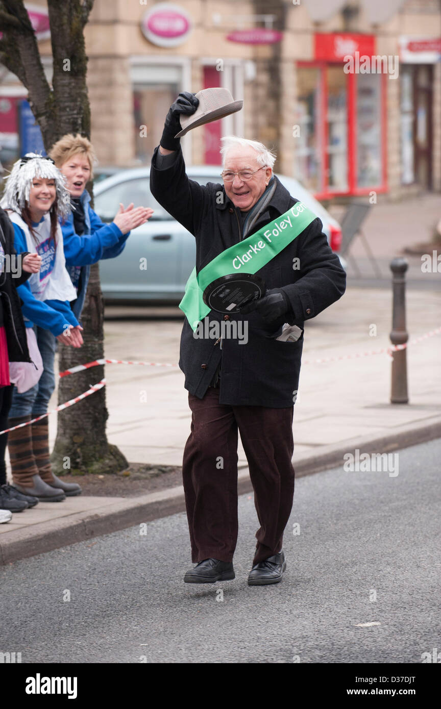 Elderly male competitor (smiling & raising his hat to crowd) taking ...