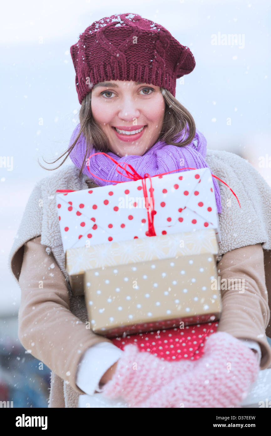 USA, New Jersey, Jersey City, Portrait of young woman carrying stack of ...