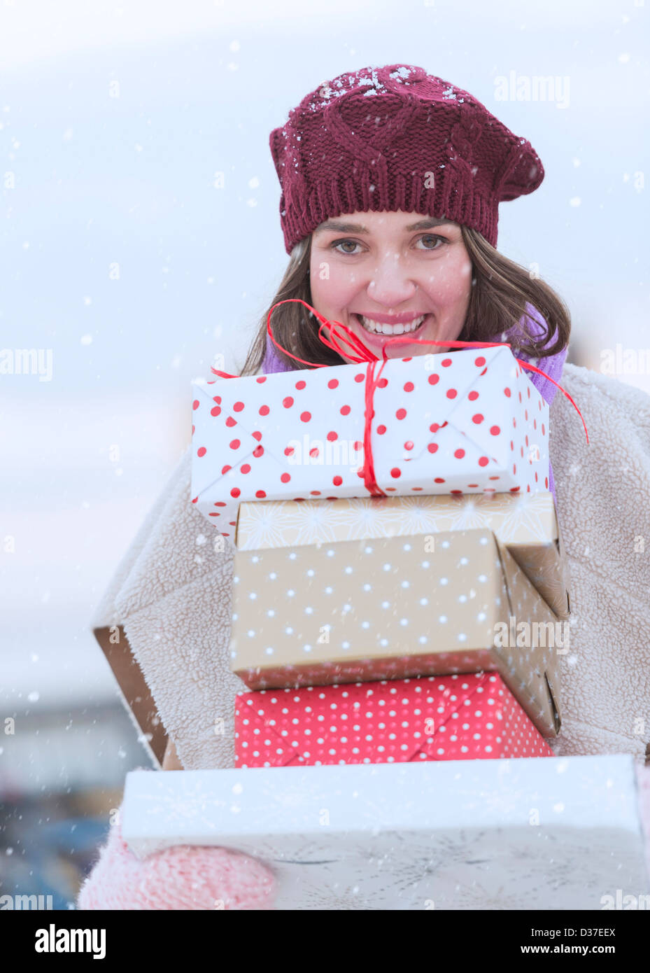 USA, New Jersey, Jersey City, Portrait of young woman carrying stack of ...